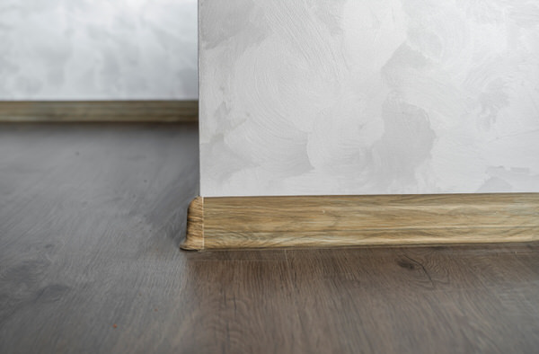 Laminate with plastic baseboard with a wooden texture. Newly installed ...